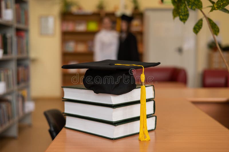 Graduation Cap on a Stack of Books in the Library. Stock Image - Image ...