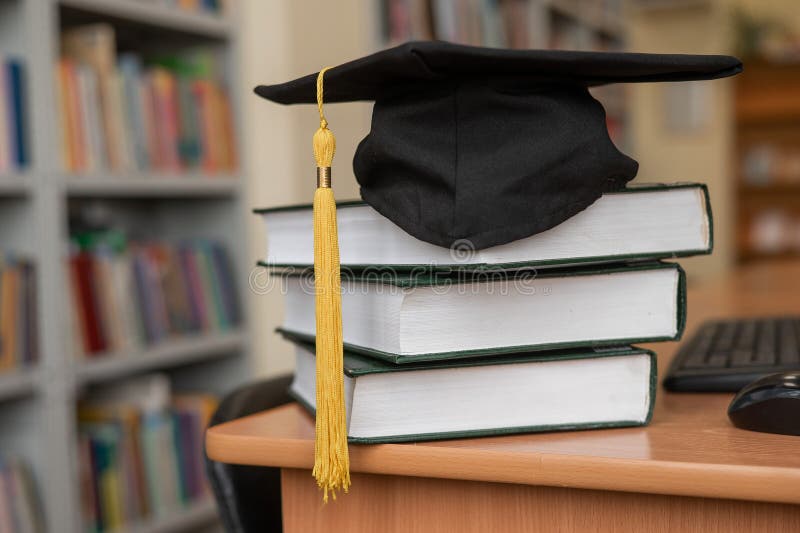 Graduation Cap on a Stack of Books in the Library. Stock Photo - Image ...
