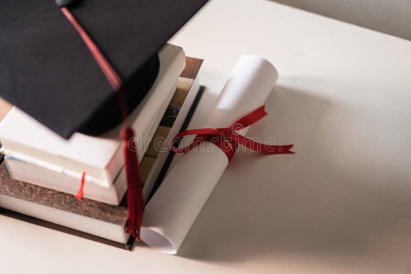 A Graduation Hat or Mortarboard and Diploma Certificate Paper Tied with ...