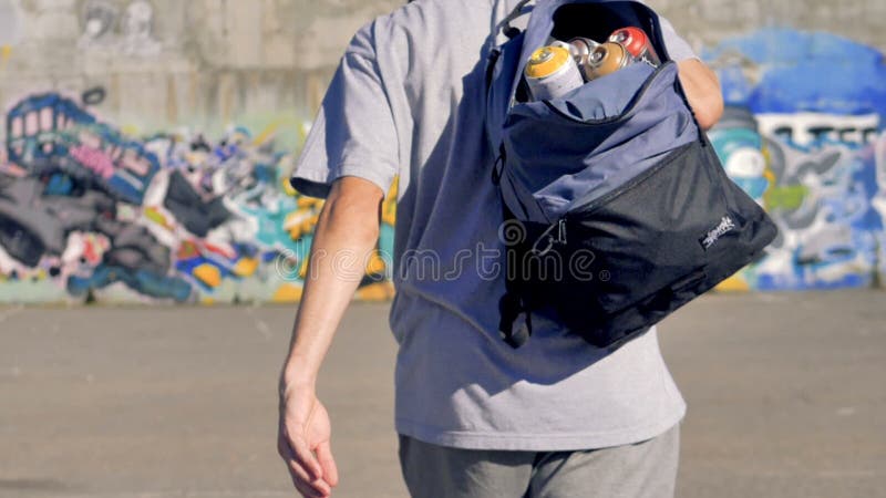 A Graffitist Puts on an Open Backpack Full of Paint Cans. Stock Footage ...