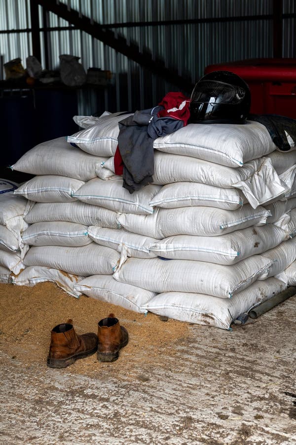 Grain Sacks Stacked in Rustic Warehouse with Boots and Helmet in Work ...