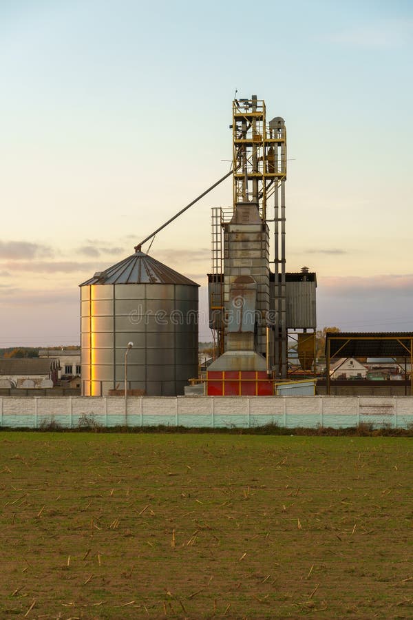 Grain Silo Elevator at Sunset Against the Background of Clouds. Iron ...