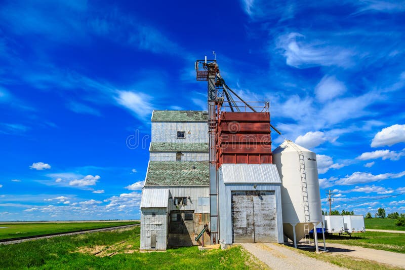 A Grain Silo is Surrounded by a Field and the Sky is Blue Stock Image ...