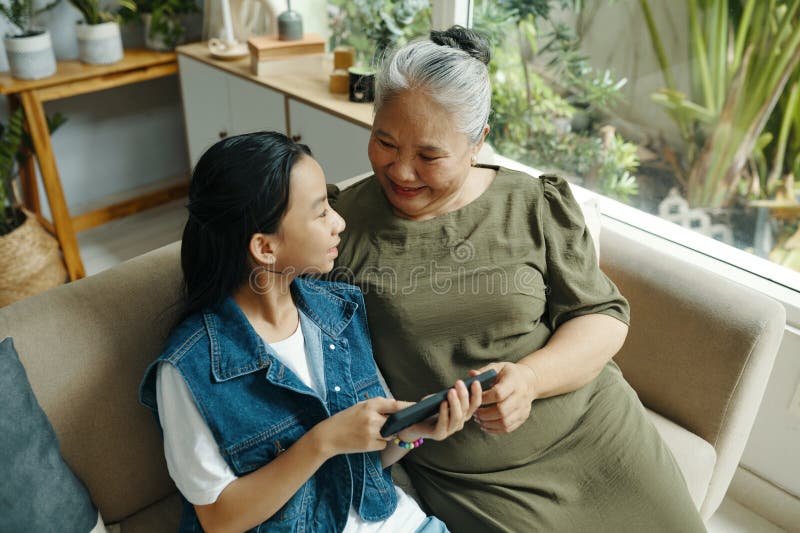 Granddaughter Talking To Her Grandma Stock Photo - Image of sofa ...