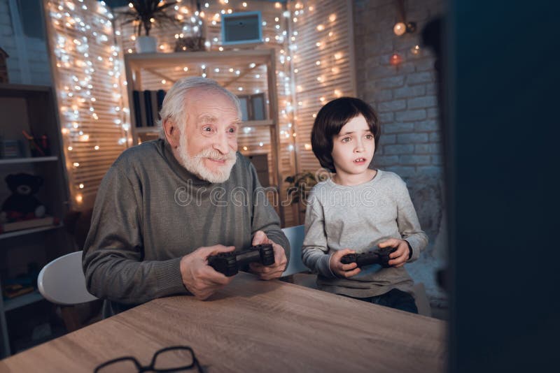 Grandfather and Grandson are Playing Video Games on Computer at Night ...