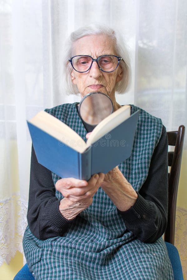 Grandma Reading a Book through Magnifying Glass Stock Photo - Image of ...