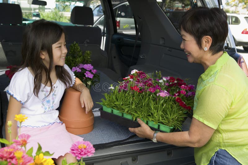 Grandmother and Granddaughter Loading Flowers into Back of SUV Stock ...