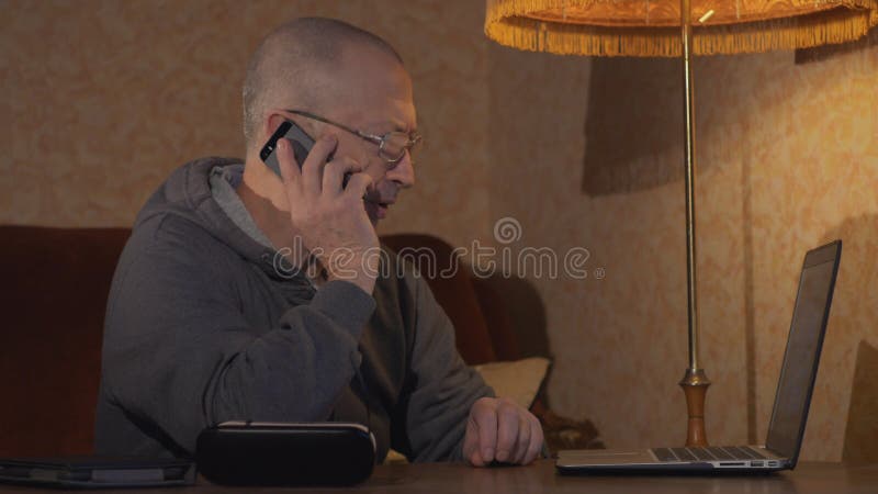 Grandpa Sitting at a Desk and Working at a Laptop. is Typing. Stock ...