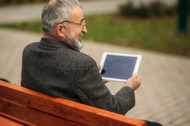 Grandpa Use a Tablet Sitting in the Park on the Bench Stock Photo ...