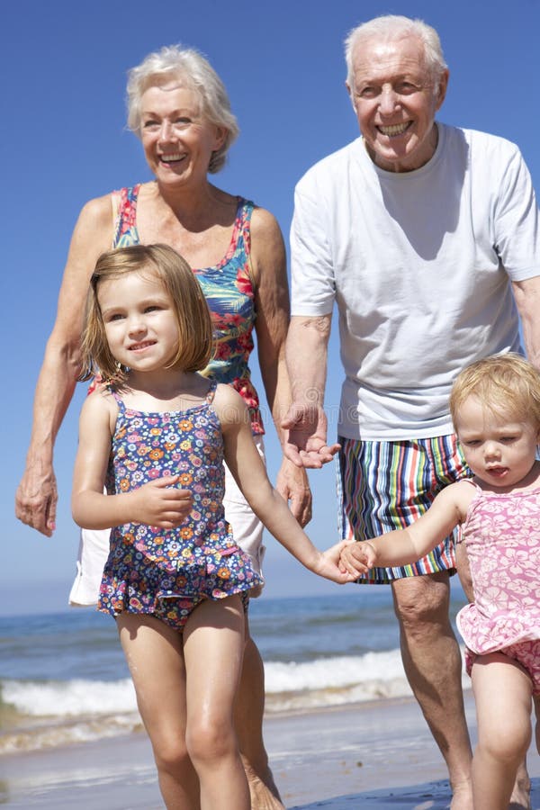 Grandparents and Grandchildren Running Along Beach Stock Photo - Image ...