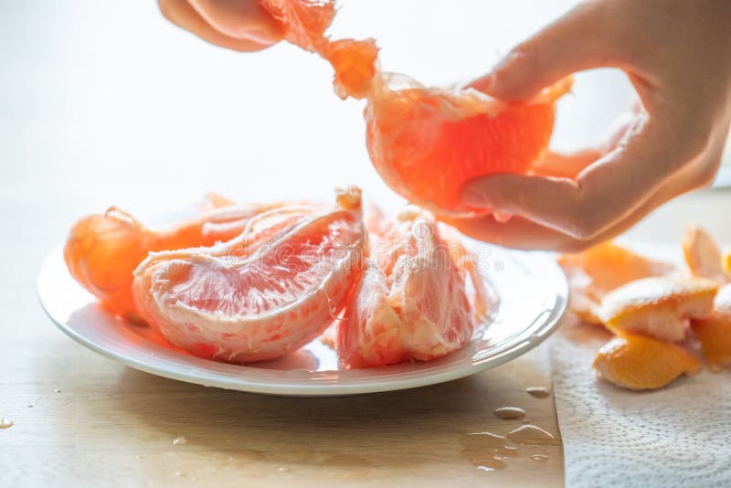 Grapefruit.Citrus Fruit.Womans Hands Peeling a Grapefruit.Fresh and ...