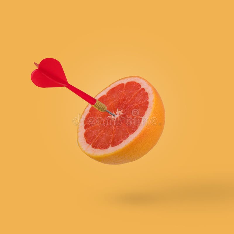 Grapefruit Slice, Fruit with Circular Target Marked and Red Dart on a ...