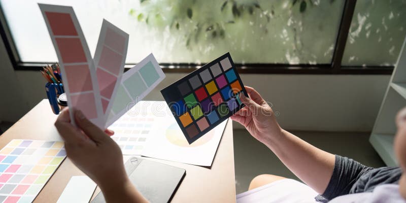 Graphic Designer Analyzing Color Palettes and Samples at a Creative ...