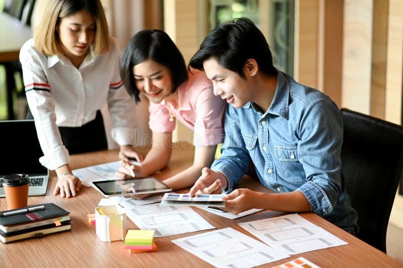 Graphic Designer Team is Working in the Office. they Use Laptop and ...