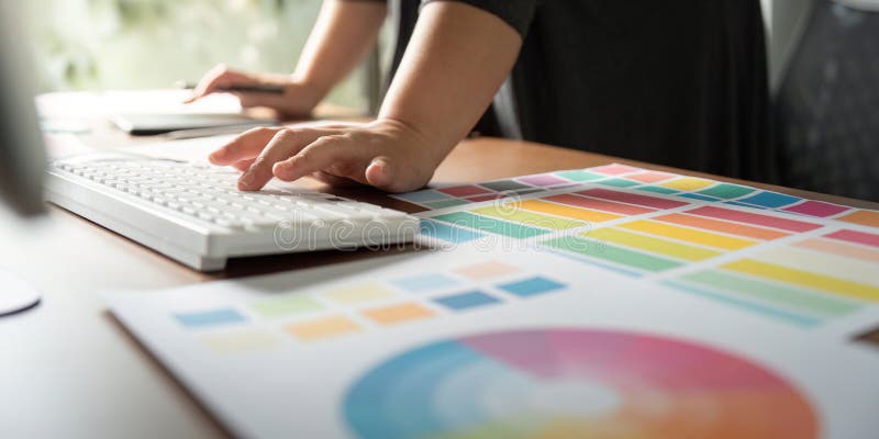 Graphic Designer Working on a Computer Keyboard with Color Charts at a ...