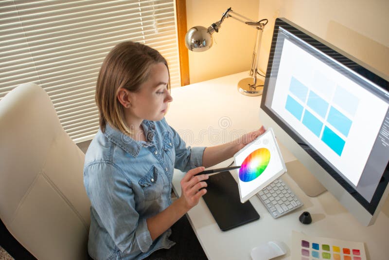 Graphic Designer Works on a Computer Using a Graphic Tablet on a Table ...