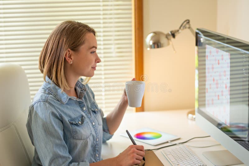 Graphic Designer Works on a Computer Using a Graphic Tablet on a Table ...