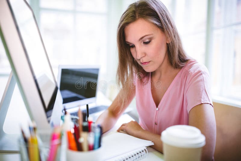 Graphic Designer Writing on Book at Desk Stock Photo - Image of ...