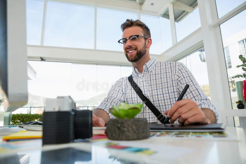Graphic Designer Writing on Tablet while Sitting at Desk Stock Image ...