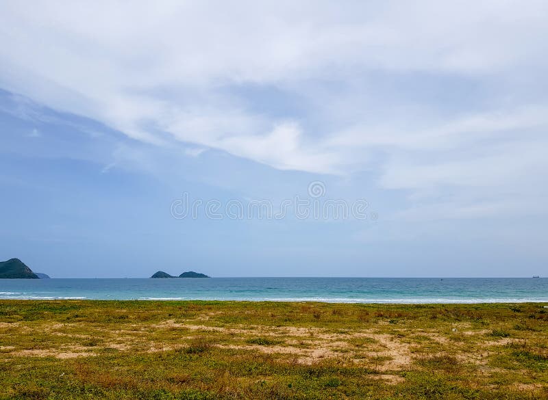 Grass Field Beach with Islands at the Horizon and Blue Sea and S Stock ...
