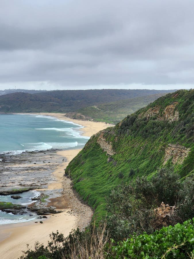 A Grassy Cliff Overlooking the Ocean and Beach on a Grey Cloudy Day ...