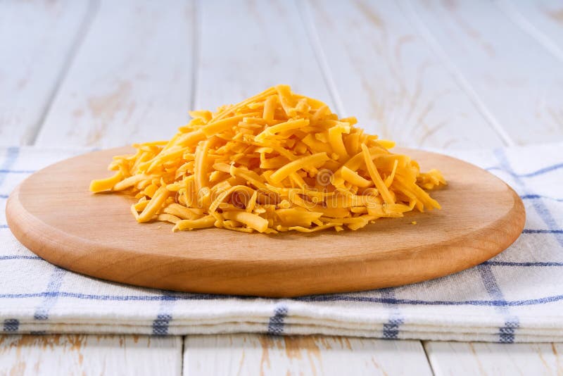 Grated Cheddar Cheese on a White Wooden Table, Copy Space for Text ...