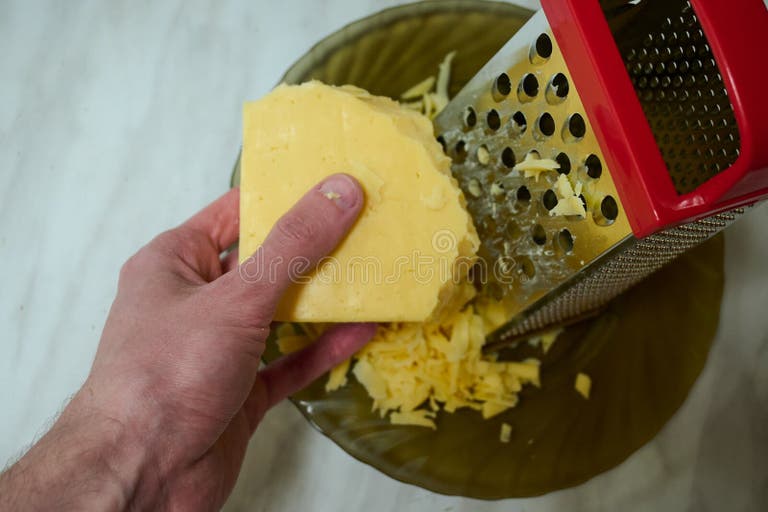 Grated Cheese on Red Grater in Kitchen Bowl Stock Photo - Image of ...
