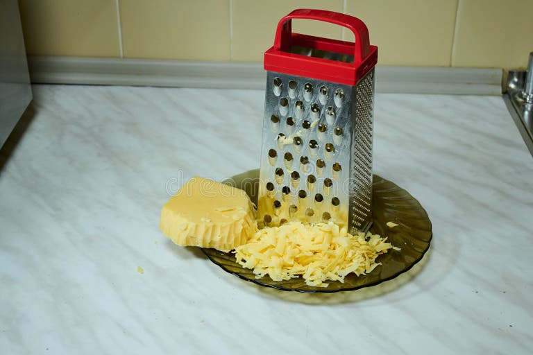 Grated Cheese on Red Grater in Kitchen Bowl Stock Photo - Image of ...