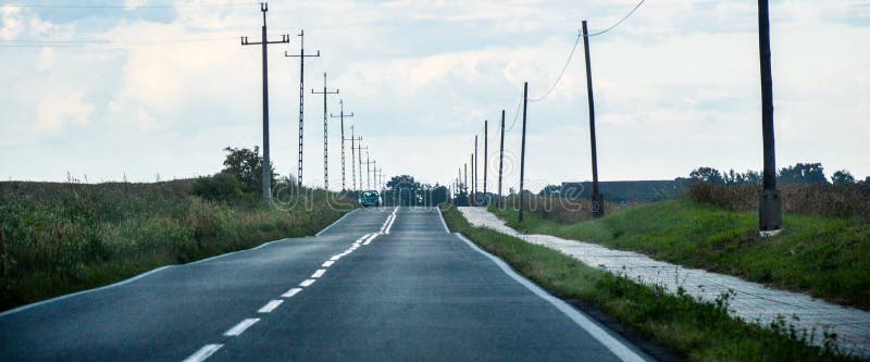 Gray Asphalt Road Between Green Grass And Gray Electric Post During ...