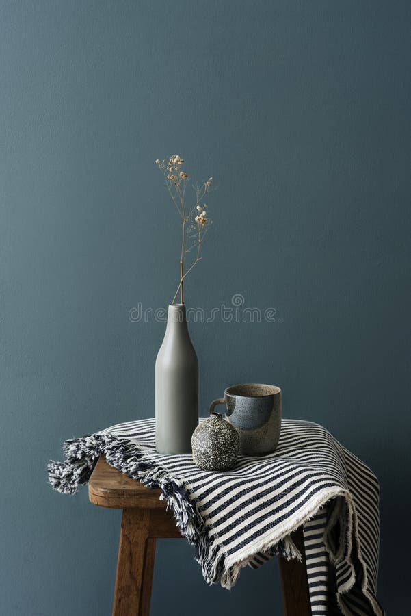 Gray Ceramic Vase with a Mug on a Wooden Stool by a Forest Green Wall ...