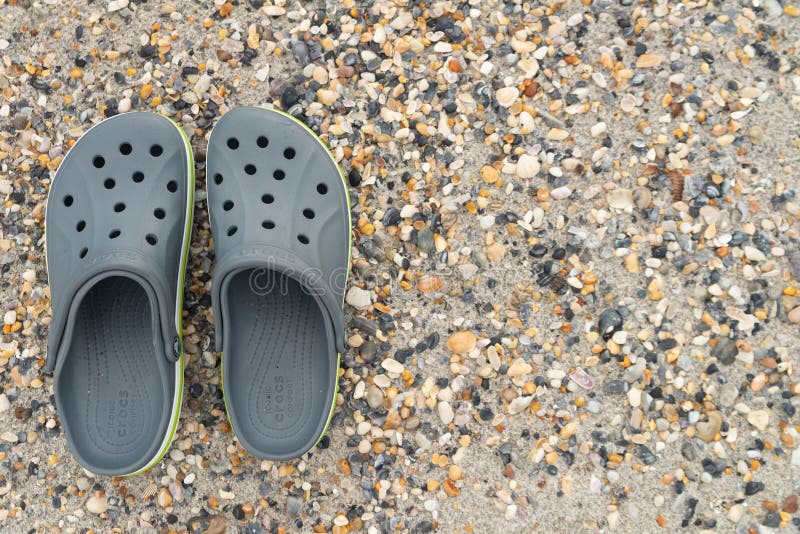 Gray Crocs Sandals Rest Gently on the Sandy Shore, Top View. Space for ...