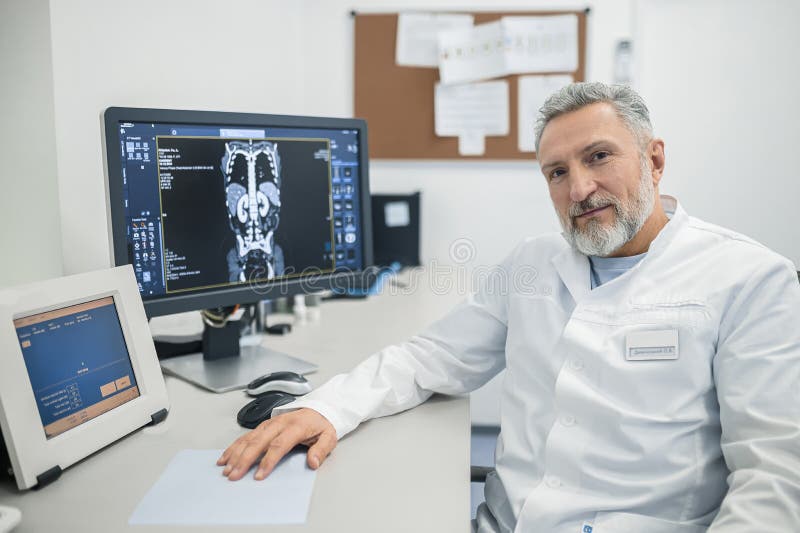 Gray-haired Doctor in a Lab Coat Sitting at His Working Place Stock ...