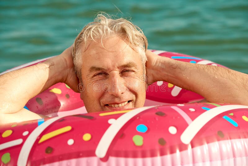 Gray-haired Funny Man Swims on Inflatable Circle in the Sea Stock Photo ...