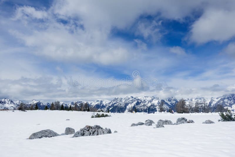 Gray Rocks in White Snow and a Amazing Snowy Mountain Range with Clouds ...