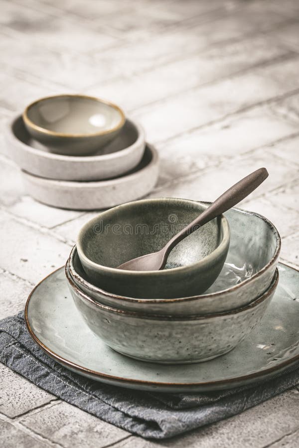 Gray Stoneware Plates and Bowls on a Rustic Table Stock Image - Image ...
