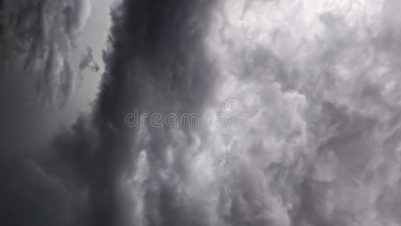 Gray Storm Clouds Move Across the Sky, Occasionally Illuminated by ...