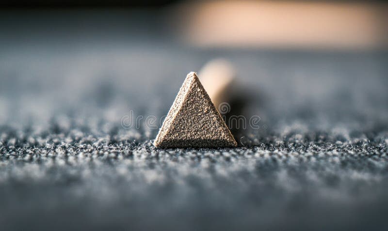 A Gray Textured Pyramid Sits Centered, Its Rough Surface Highlighted ...