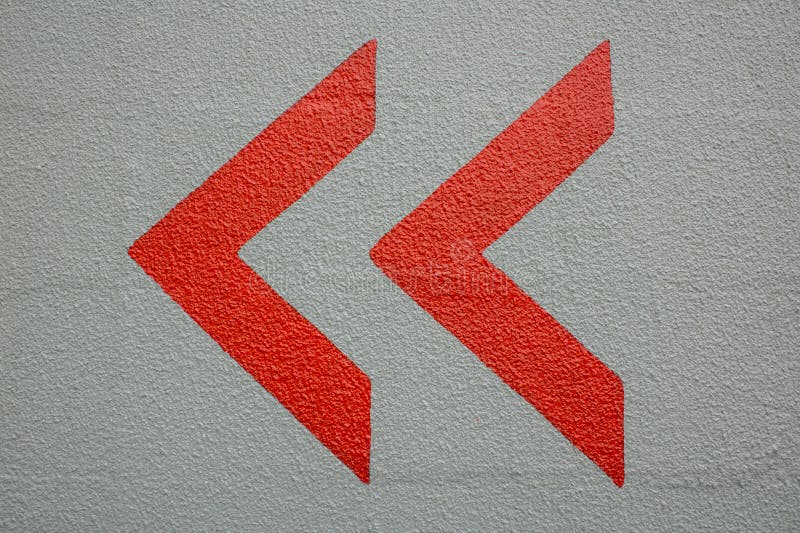 Gray Wall with Two Red less-than Signs Stock Photo - Image of arrow ...