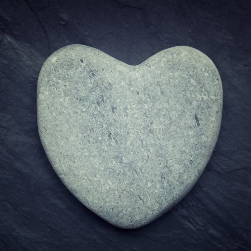 A Gray Zen Heart Shaped Rock in the Corner on a Tile Background Stock ...