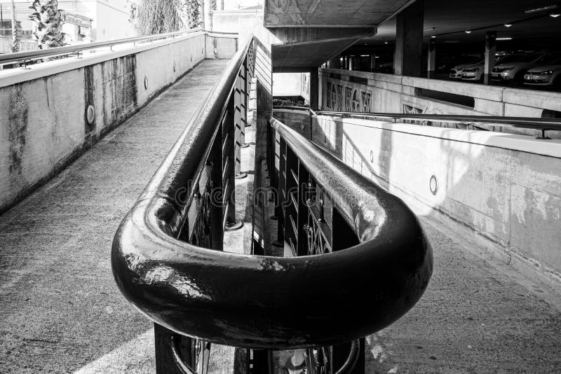 Grayscale of a Hand Railing and a Walkway with a Parking Lot in the ...
