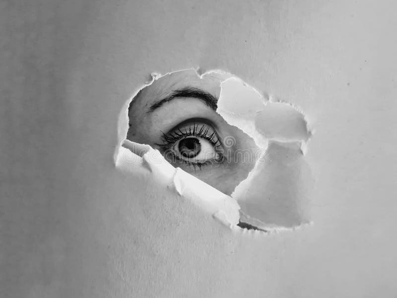 Grayscale Shot of a Female Eye Looking Behing a Torn Paper Stock Photo ...