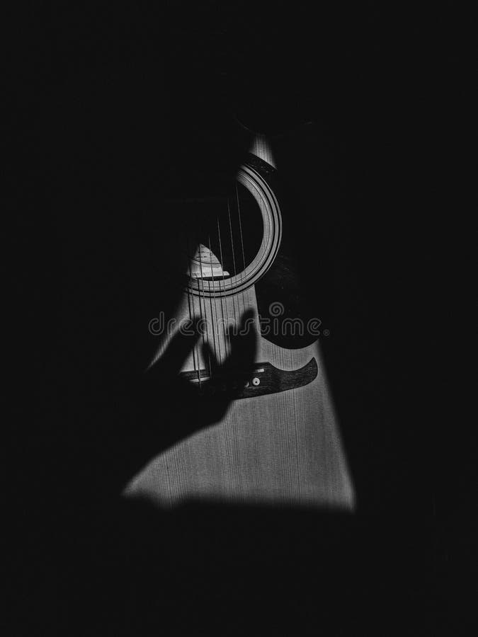 Grayscale Shot of a Hand Shadow Strumming on Guitar Strings Stock Image ...
