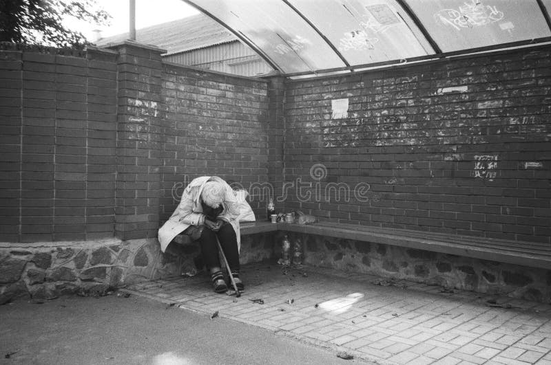 Grayscale Shot of a Homeless Old Person Sitting on a Bench Alone Stock ...
