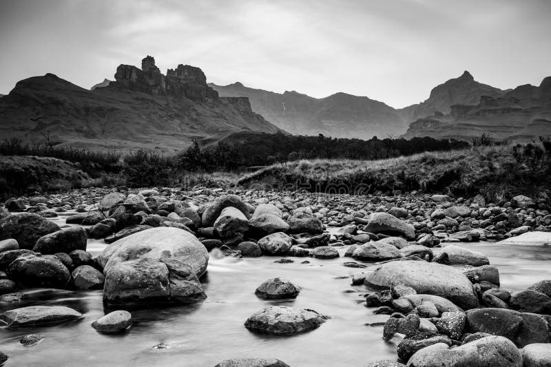 Grayscale Shot of a River with Tall Mountains in the Background Stock ...