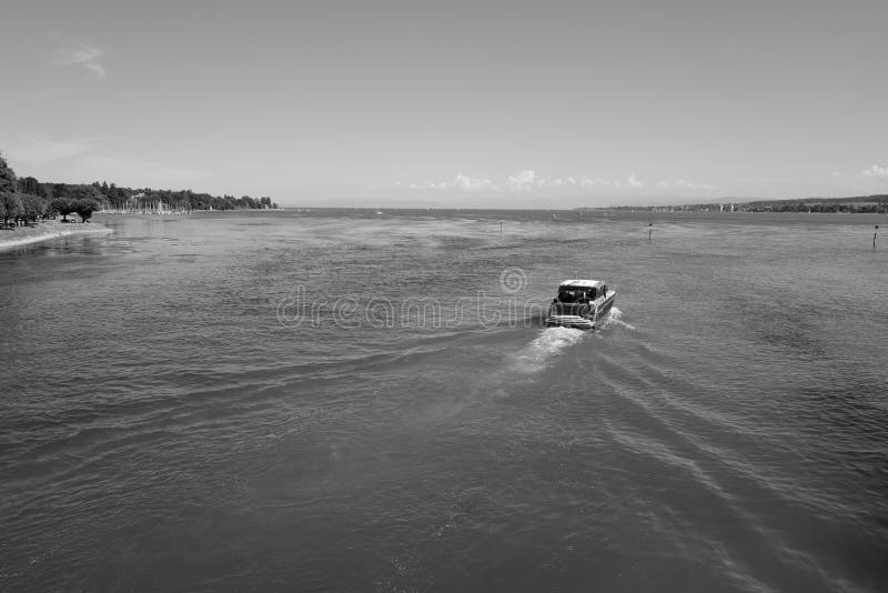 Grayscale Shot of a Small Boat Sailing on the Water Stock Photo - Image ...