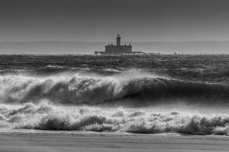 Grayscale Shot of the Strong Ocean Waves with a Lighthouse in the ...