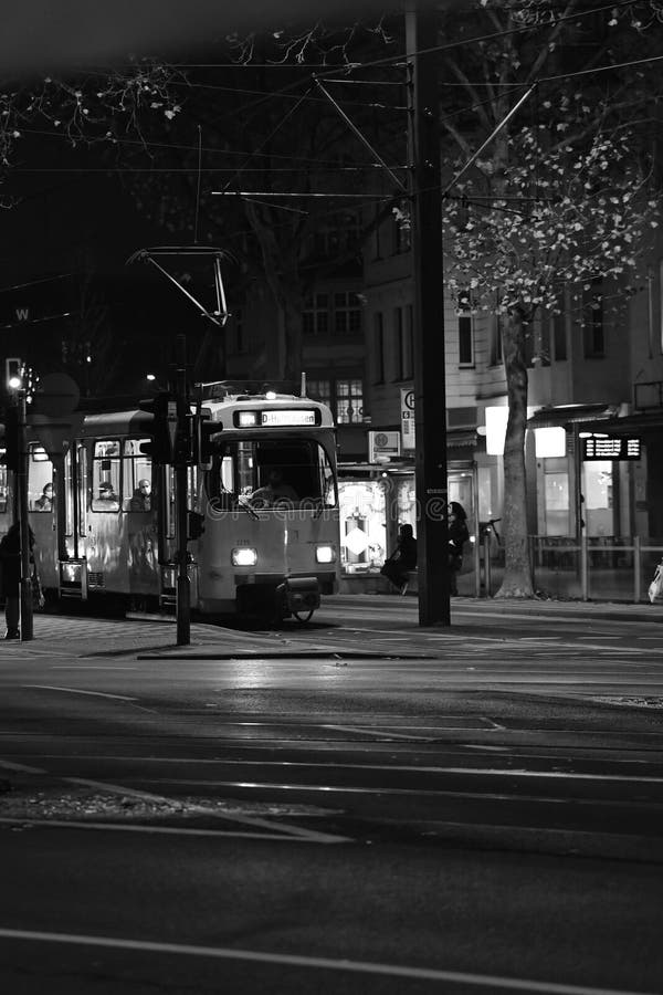 Grayscale of a Tram Going through Town Streets at Night on the Street ...