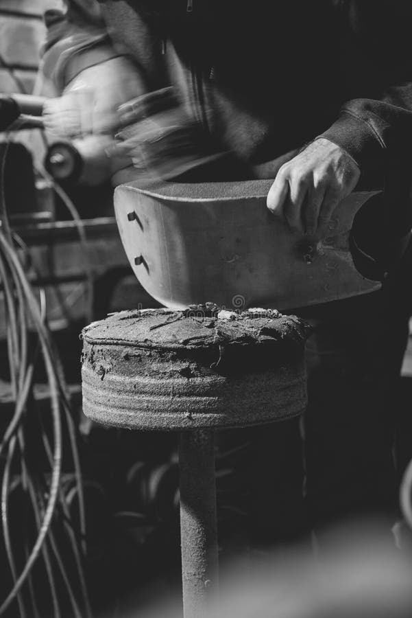 Grayscale Vertical Shot of a Man Shaping Upholstery Foam at a Workshop ...