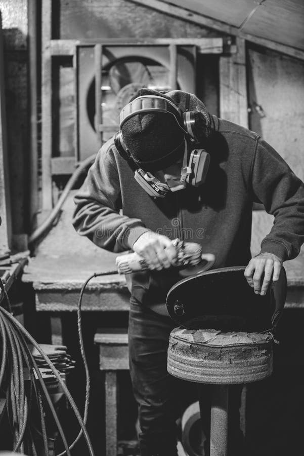 Grayscale Vertical Shot of a Man Shaping Upholstery Foam at a Workshop ...