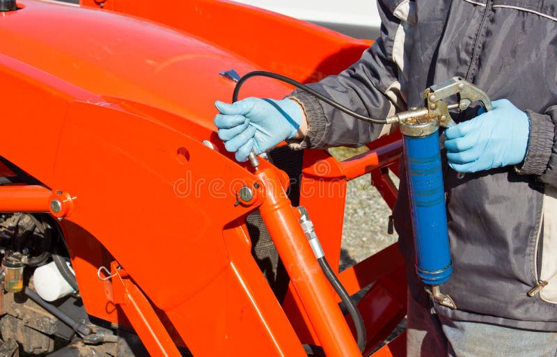 Greasing Tractor Piston stock photo. Image of employee - 23893356